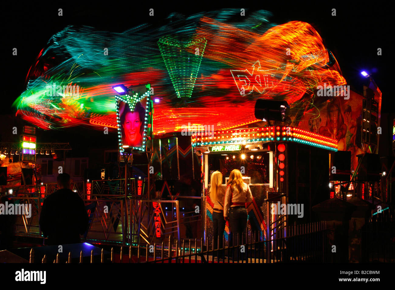 Stokesley high street fun fair at night with two customers at pay booth ...