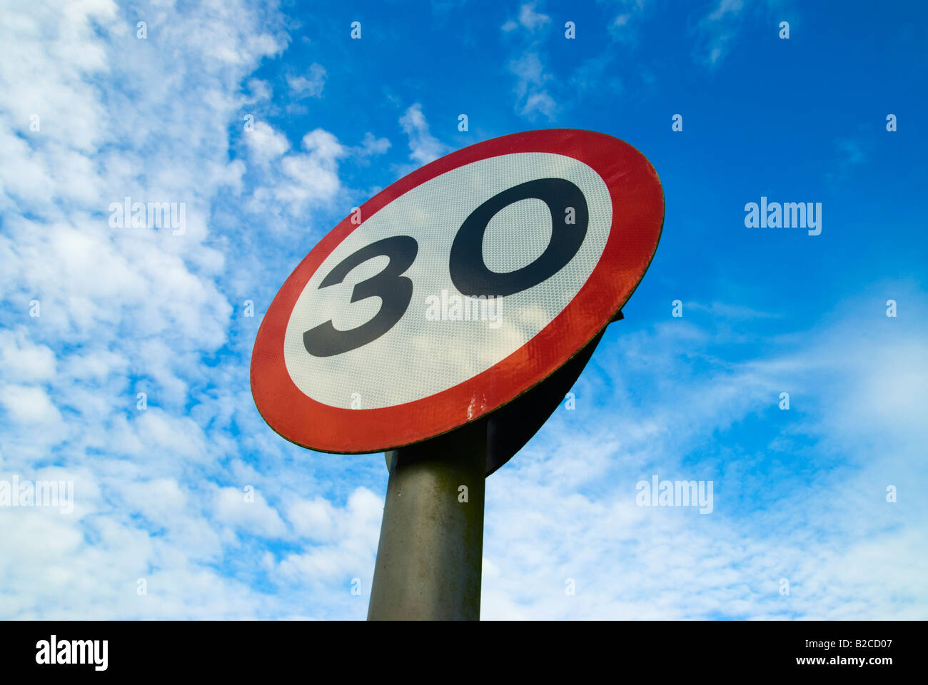 30mph speed limit sign against a blue sky with white clouds Stock Photo ...