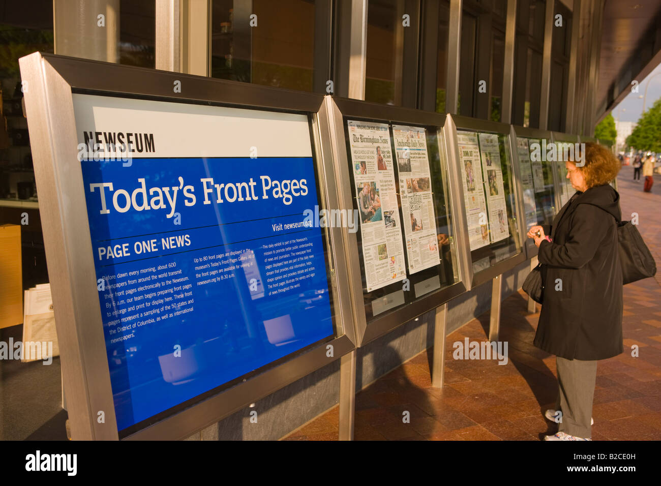WASHINGTON DC USA Woman looks over newspaper front pages at the Newseum ...
