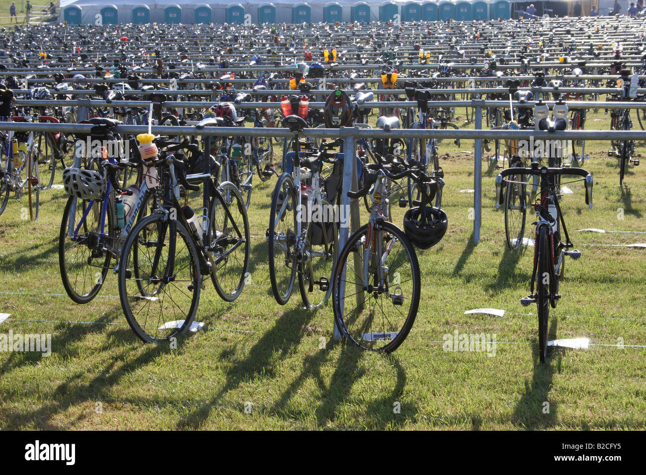 racing bycicles push bykes on transition at Ironman competition in ...