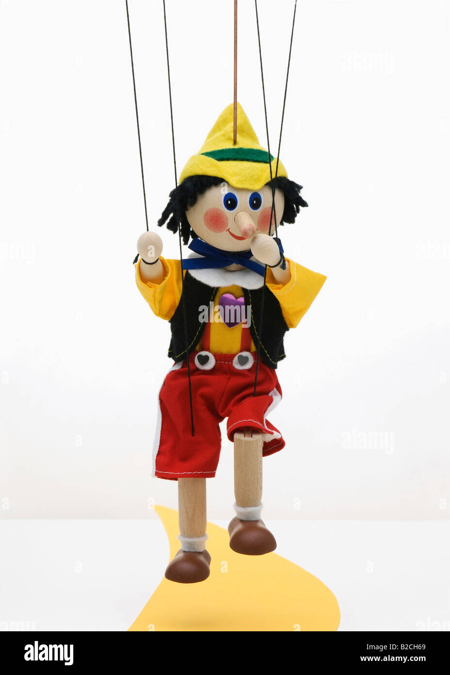 Pinocchio puppet walking on yellow brick road Stock Photo - Alamy