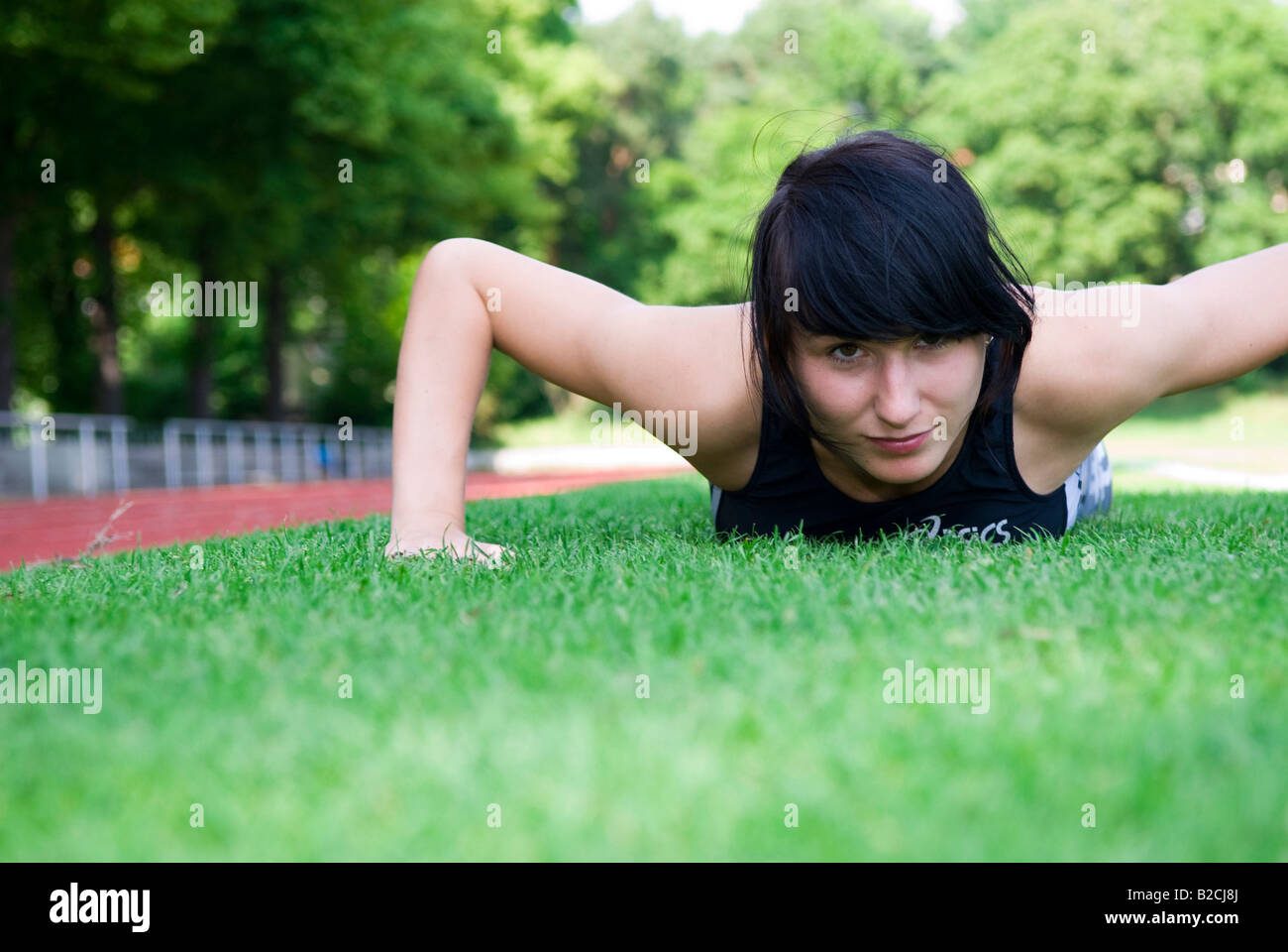 young woman doing push-ups on a lawn Stock Photo - Alamy