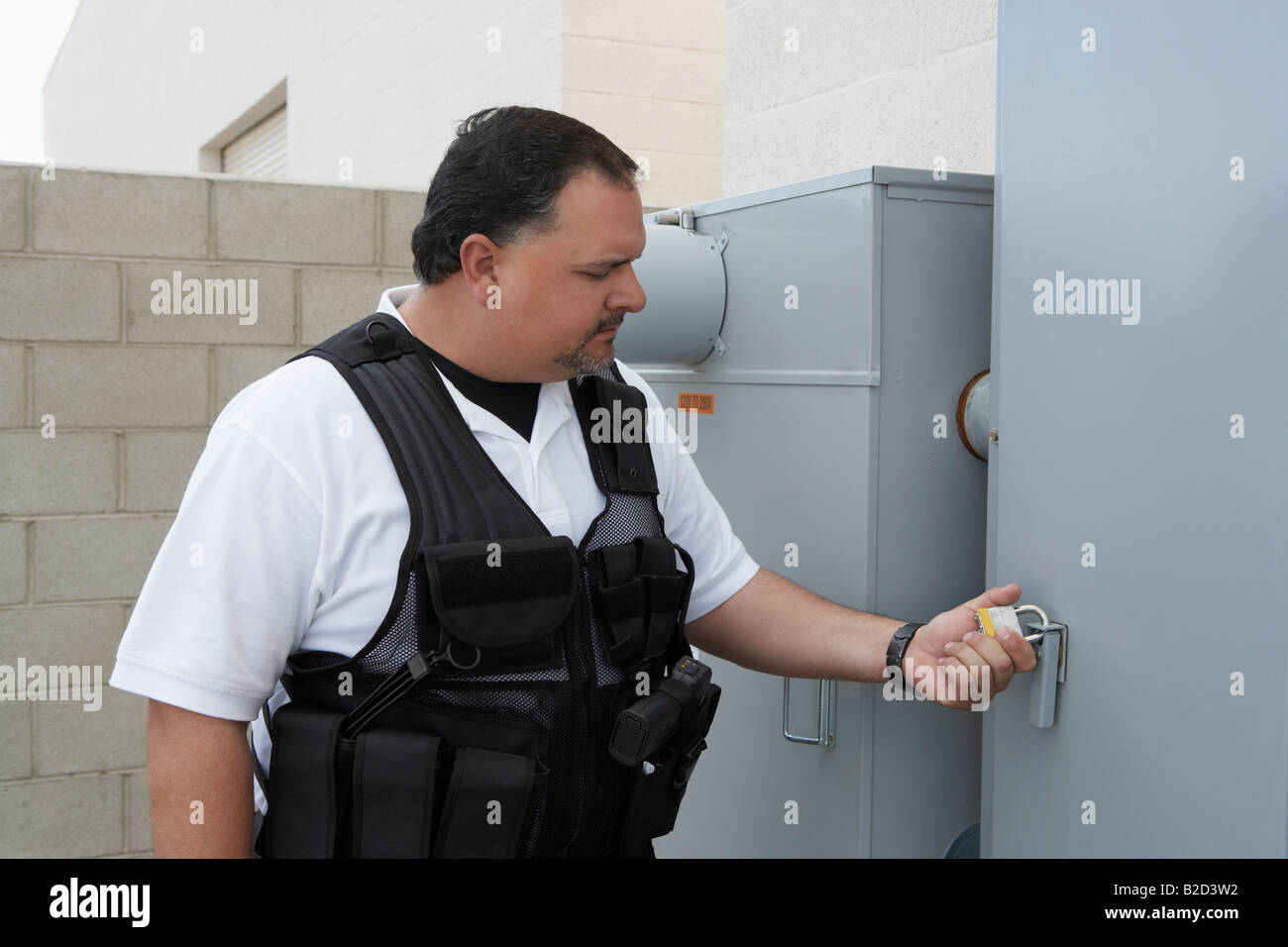 Security guard checking padlock Stock Photo - Alamy