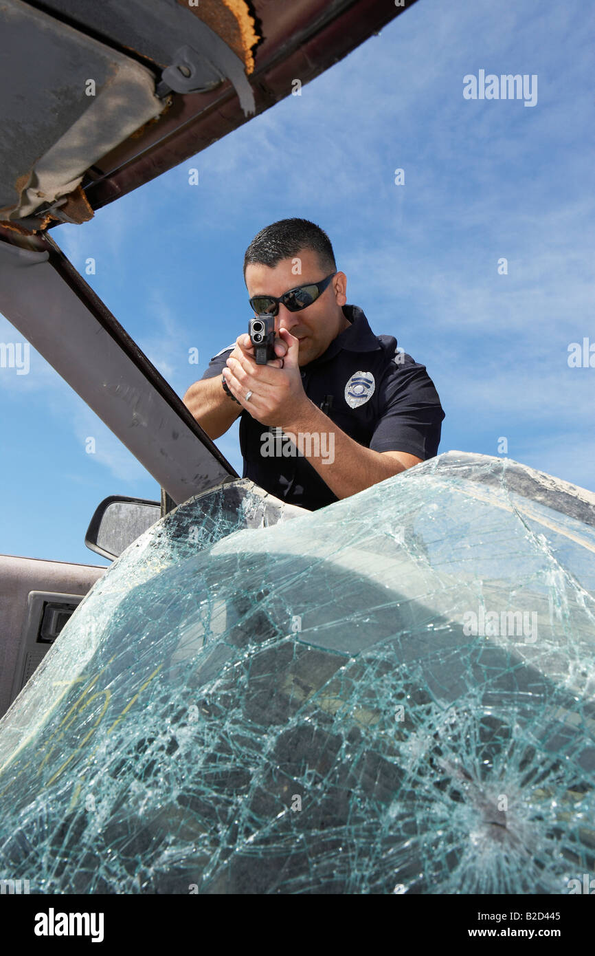 Police officer aiming gun through broken car windshield Stock Photo - Alamy