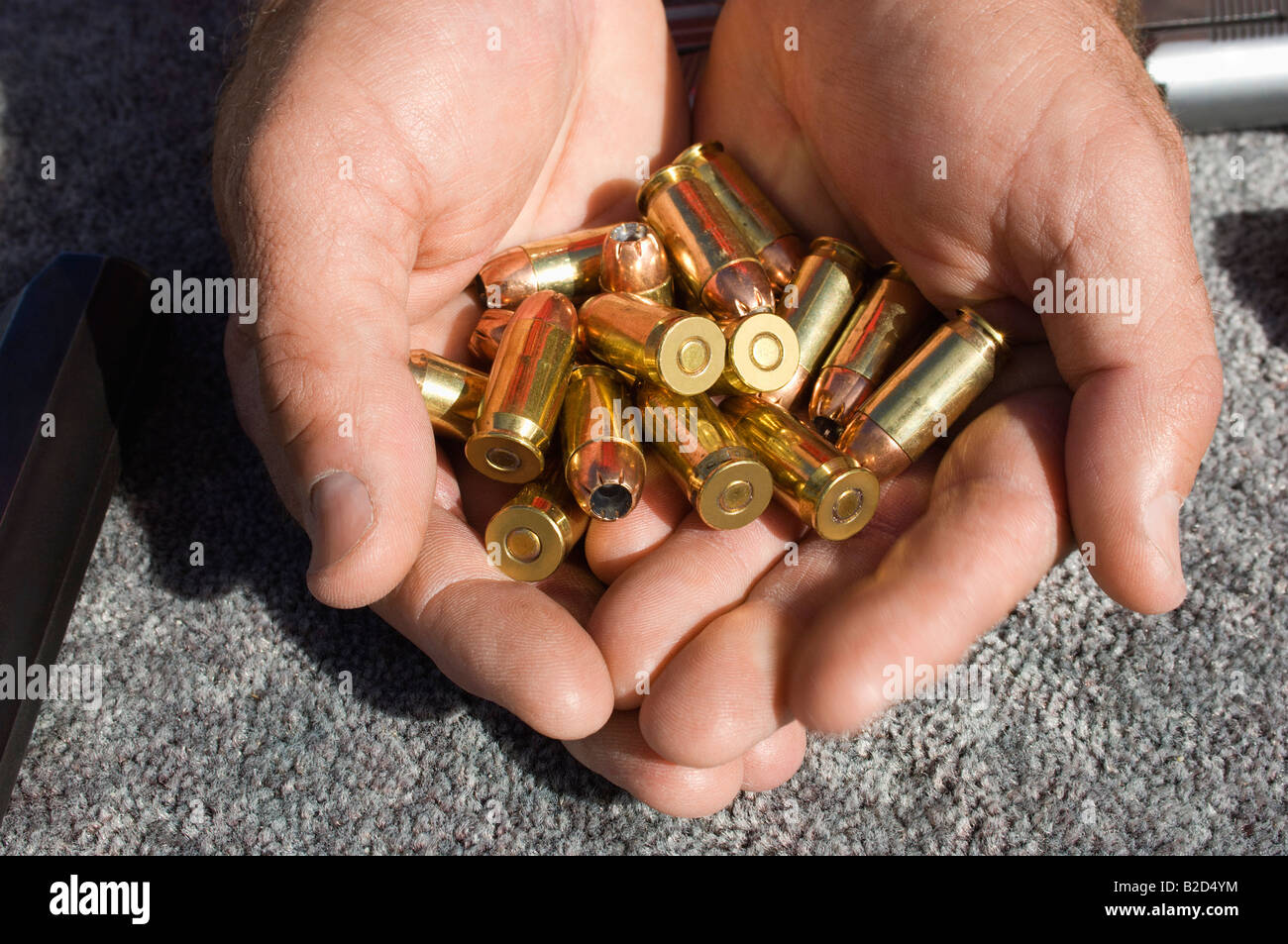 Mans hands holding bullets, close-up Stock Photo - Alamy