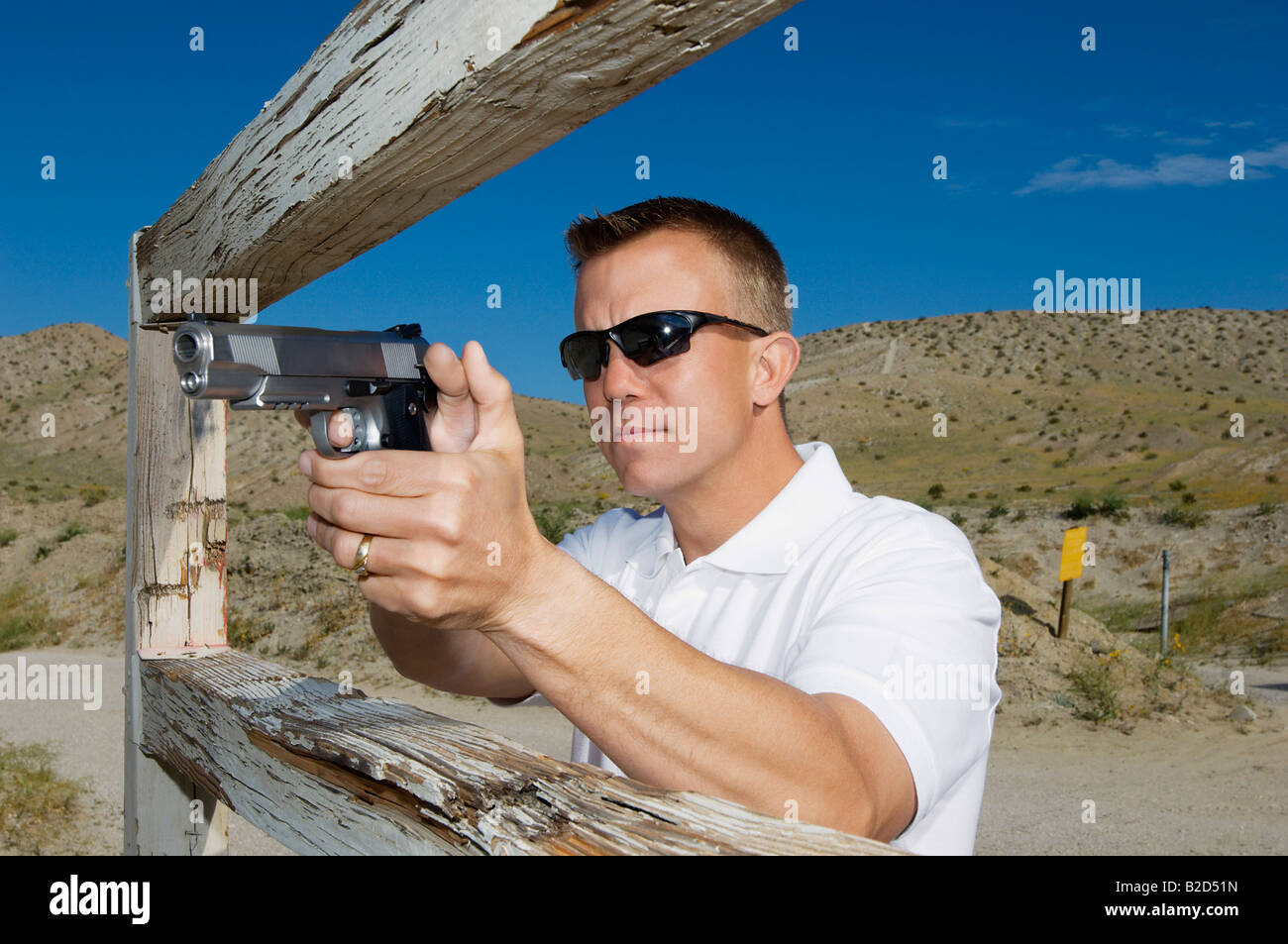 Man aiming hand gun at firing range Stock Photo - Alamy