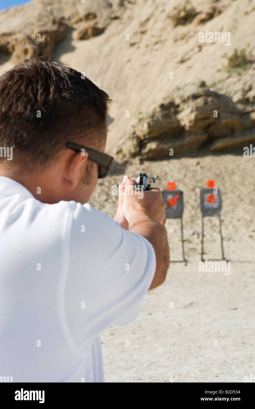 Man aiming hand gun at firing range Stock Photo - Alamy