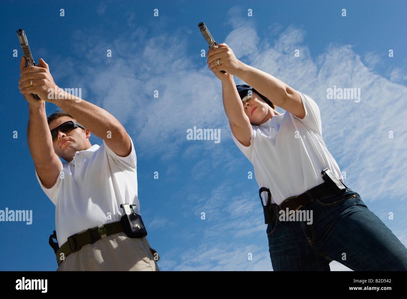 Man and woman aiming hand guns at firing range, low angle view Stock ...