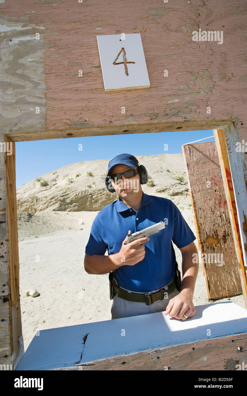 Man holding hand gun at firing range, portrait Stock Photo - Alamy