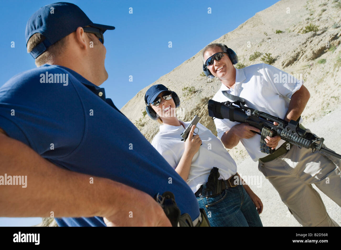 Instructor with couple at firing range in desert Stock Photo - Alamy