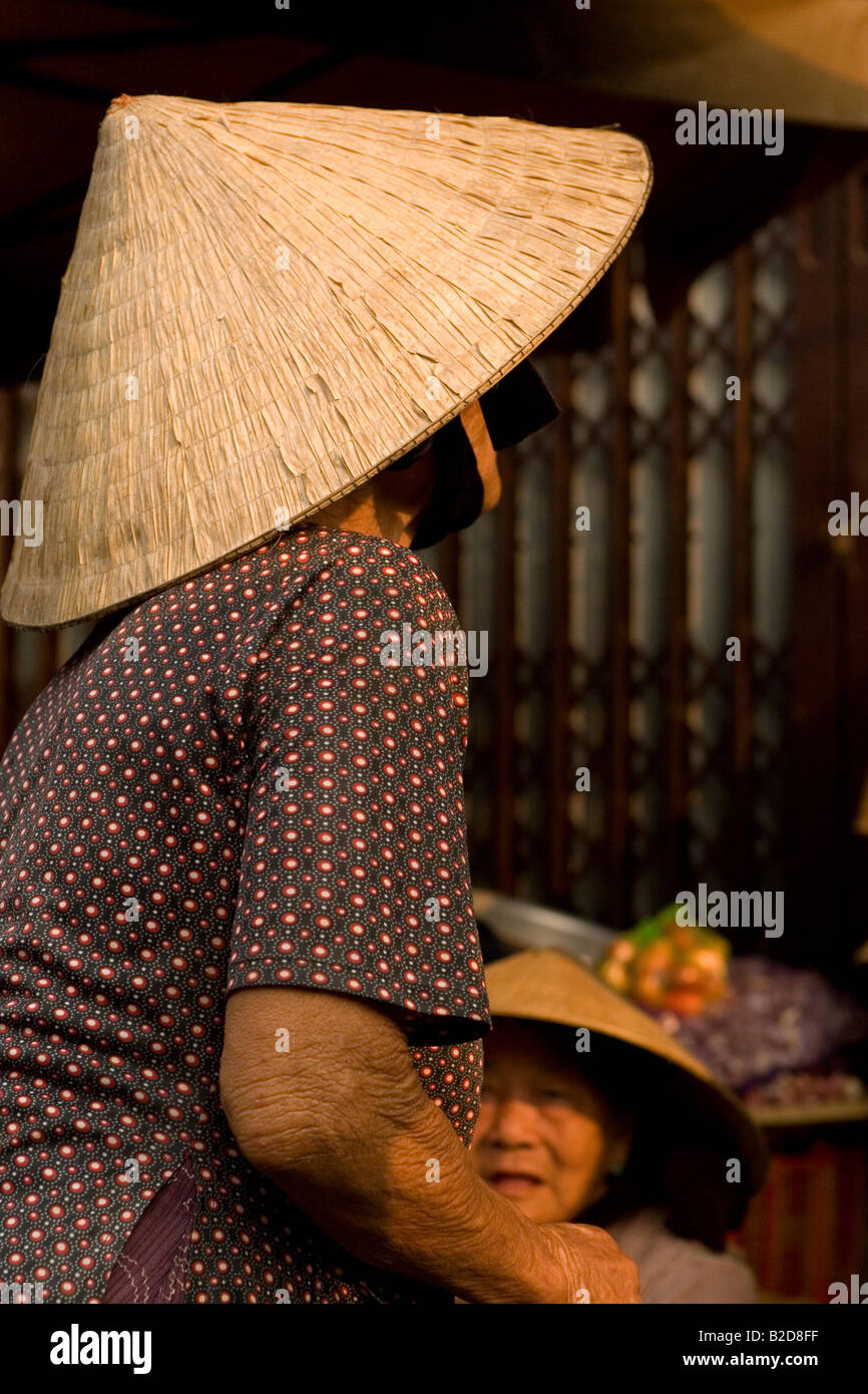Woman wearing traditional "Non La" conical hats work at the market in ...