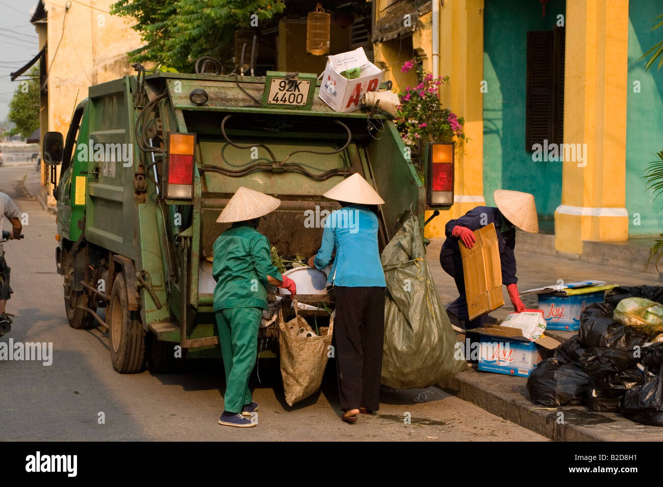 Women collect refuse on a street in Hoi An, Vietnam Stock Photo - Alamy