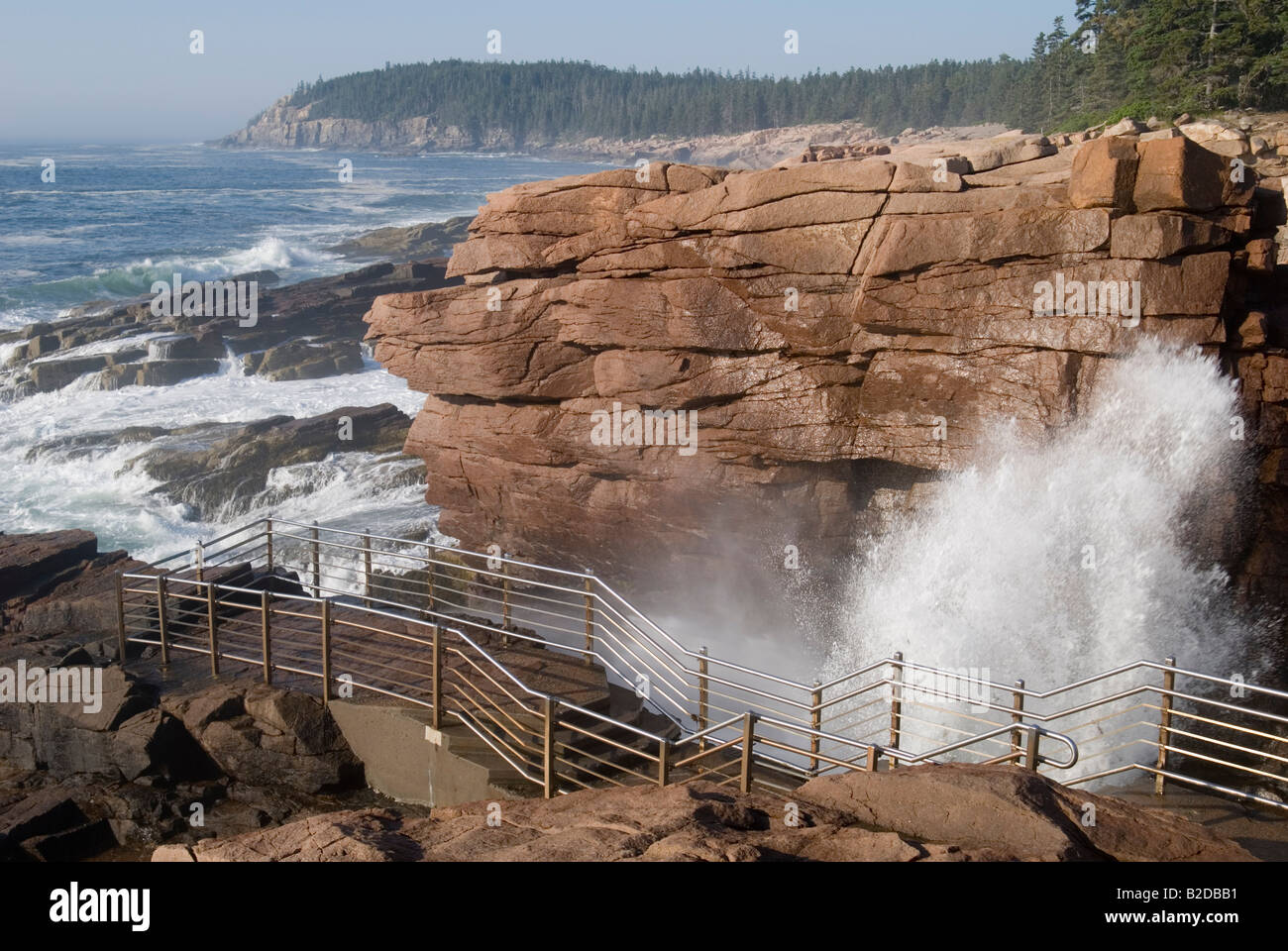Wave crashing at Thunder Hole, in Acadia National Park. Red granite in ...