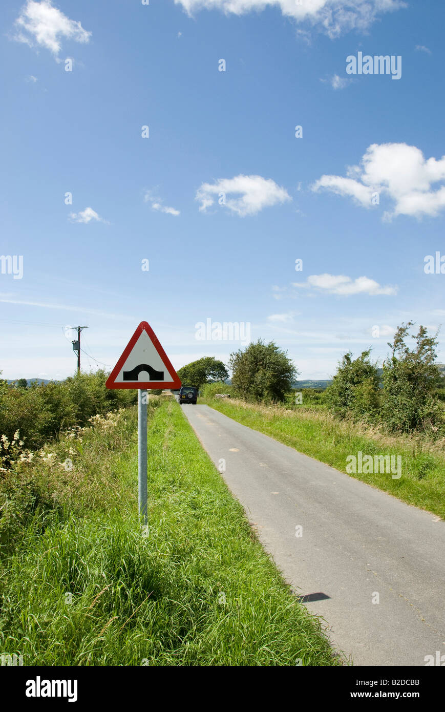 hump backed bridge roadsign on narrow country lane Stock Photo - Alamy