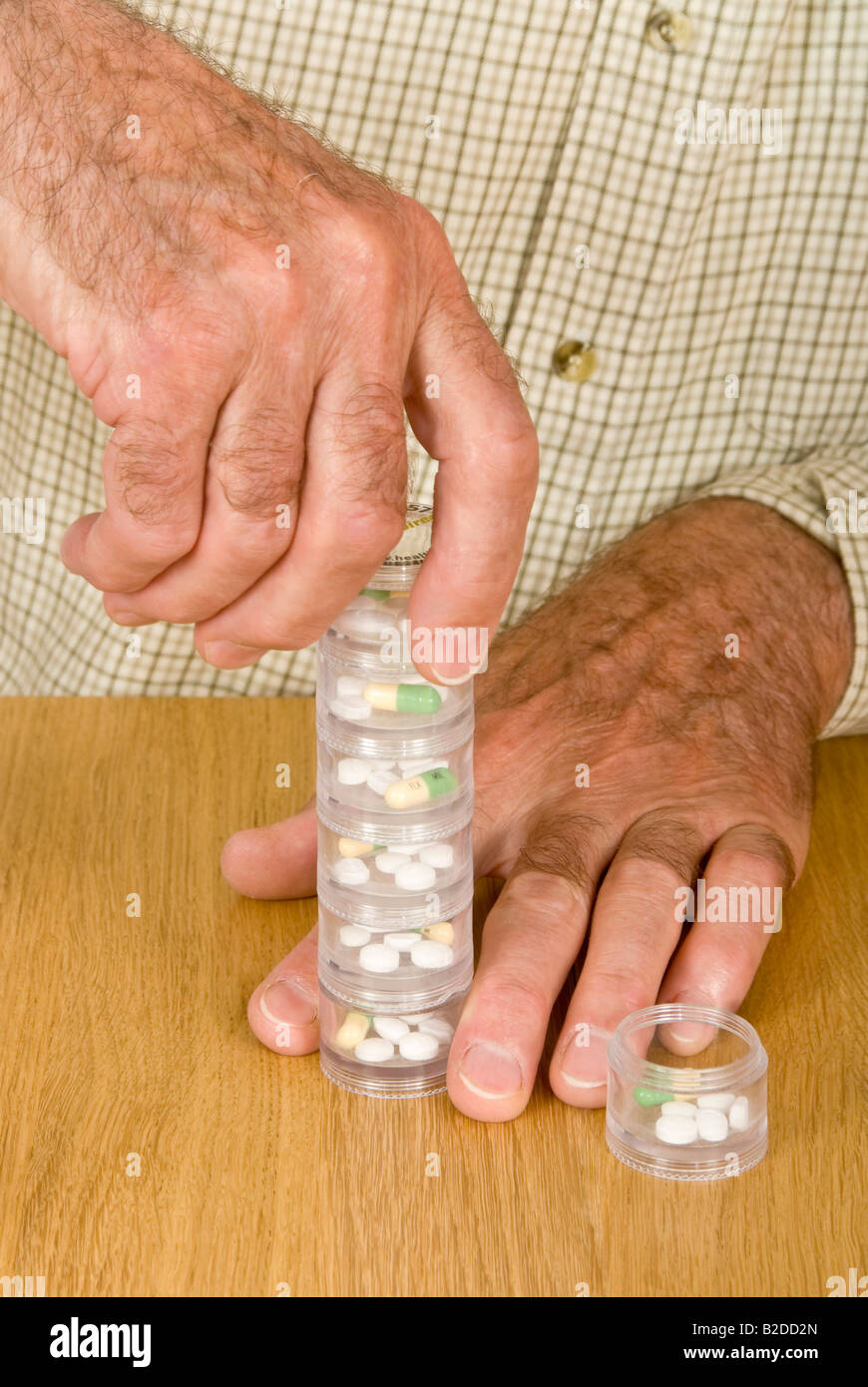 Vertical close up of an elderly gentleman organising his weekly ...