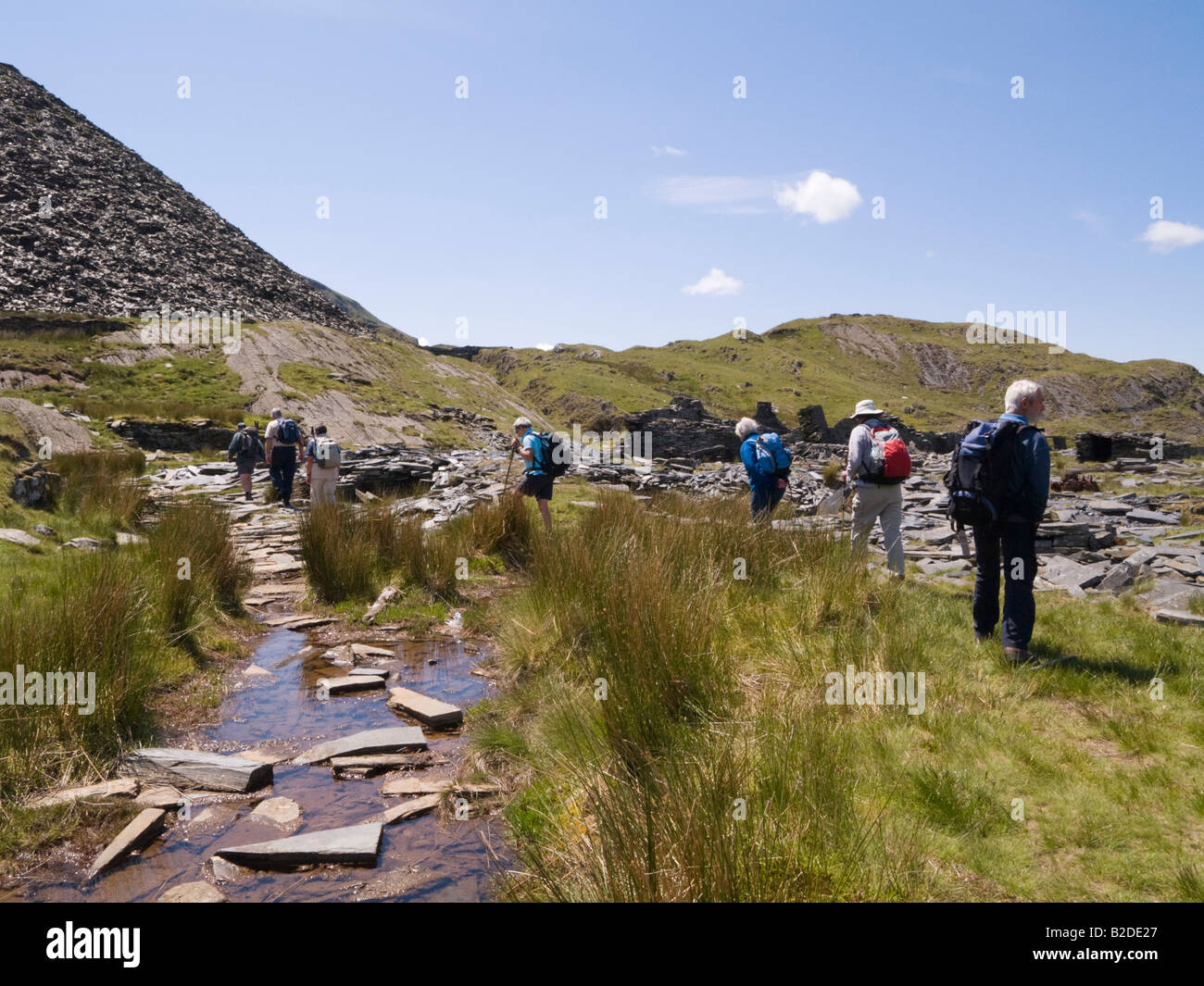 Group of walkers walking through abandoned disused Cwm Croesor slate ...