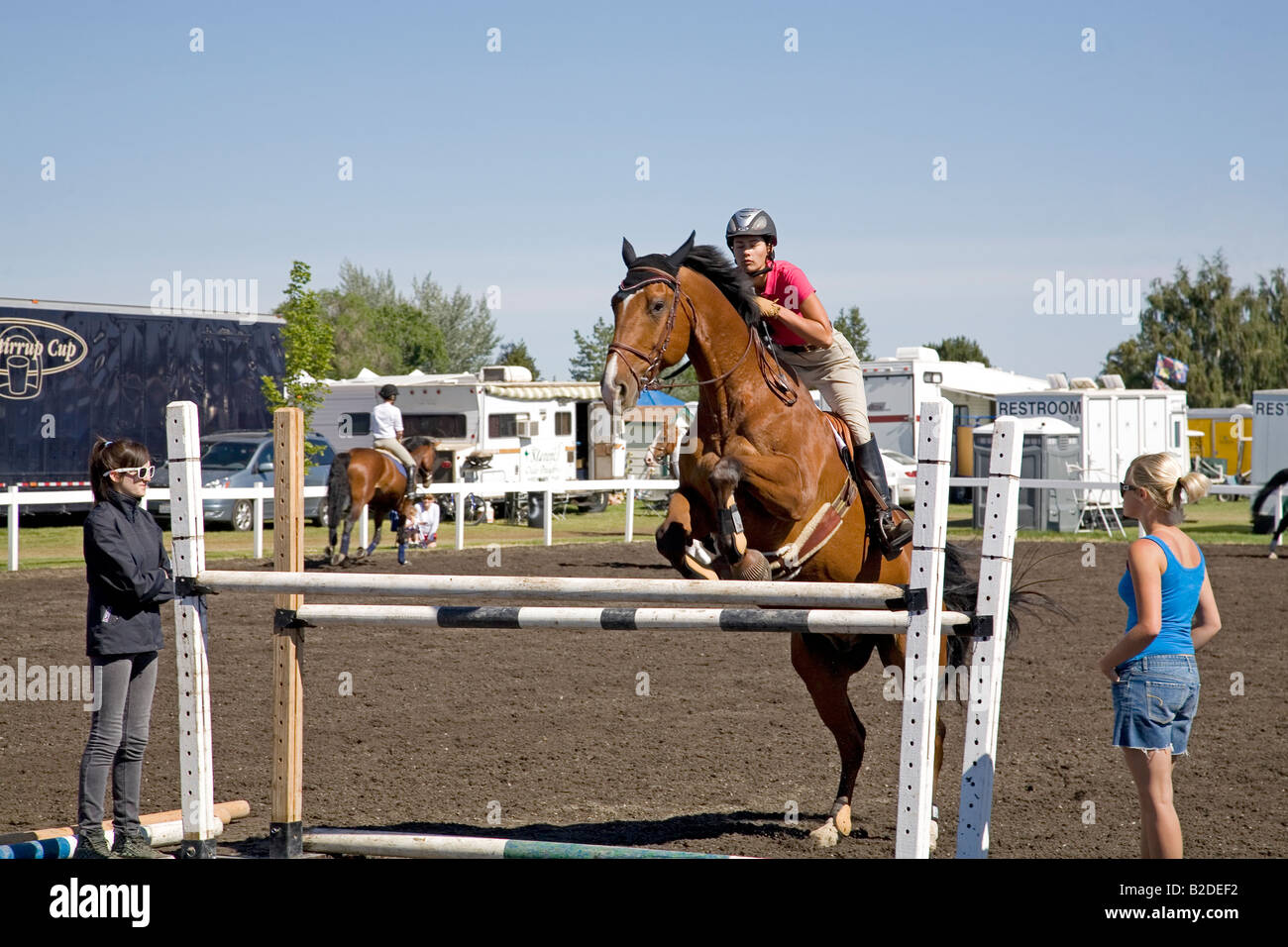 A rider takes a jump in the practice ring in preparation for the hunter ...