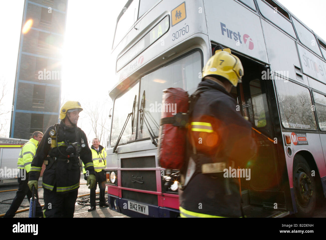 Firemen rushing to put out a fire in a bus during a satety exercise ...