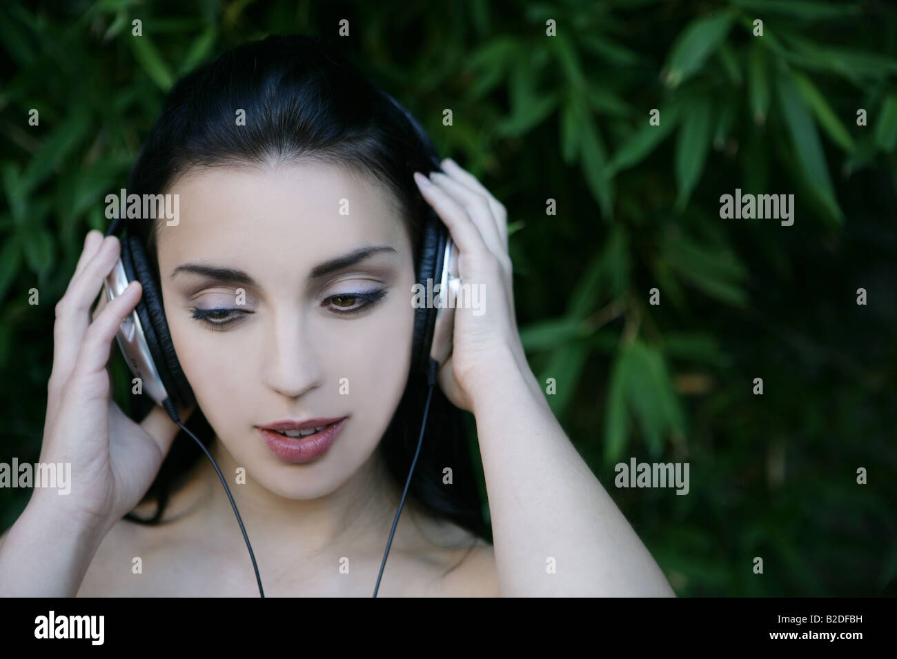 Young woman listening to headphones Stock Photo - Alamy