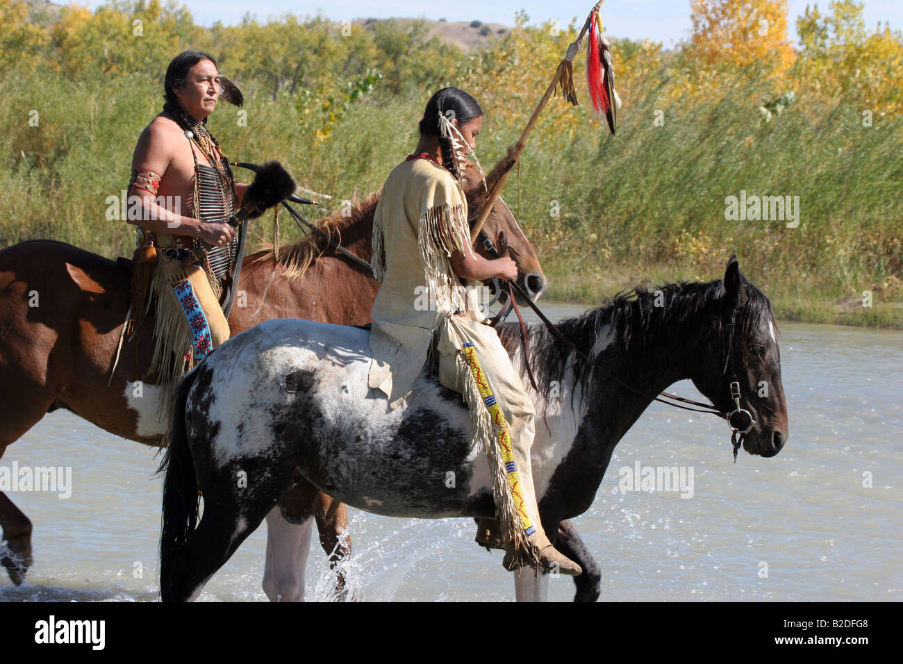 Two Native American Sioux Indian men on horseback walking through a ...
