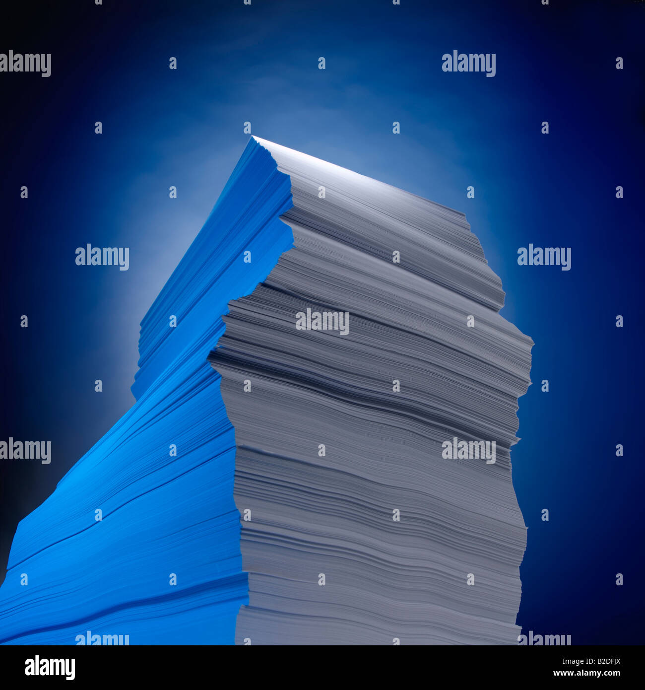 Pile of A4 paper arranged to look like a mountain against a blue sky ...