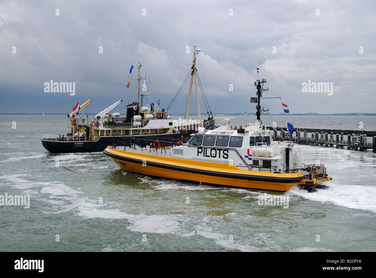 yellow pilot boat assisting freight ship with mooring Vlissingen ...