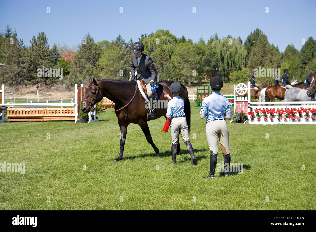 A rider takes a blue ribbon in the hunter jumper ring during an ...