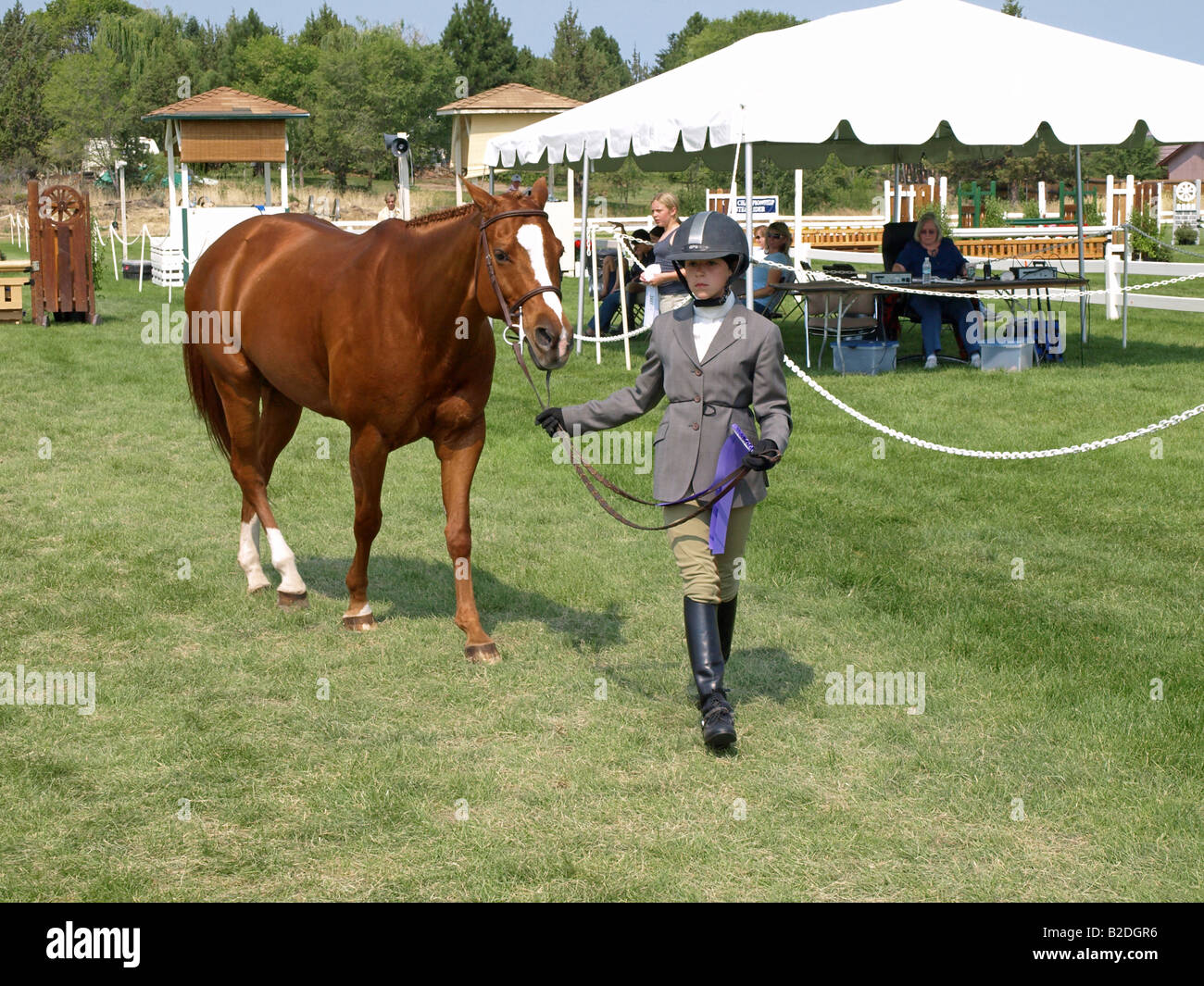 A young rider receives a blue ribbon for her performance in a hunter ...