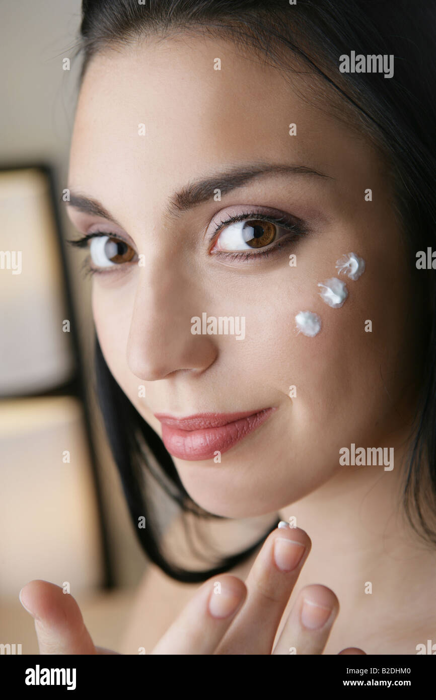 Young woman applying facial cream Stock Photo - Alamy