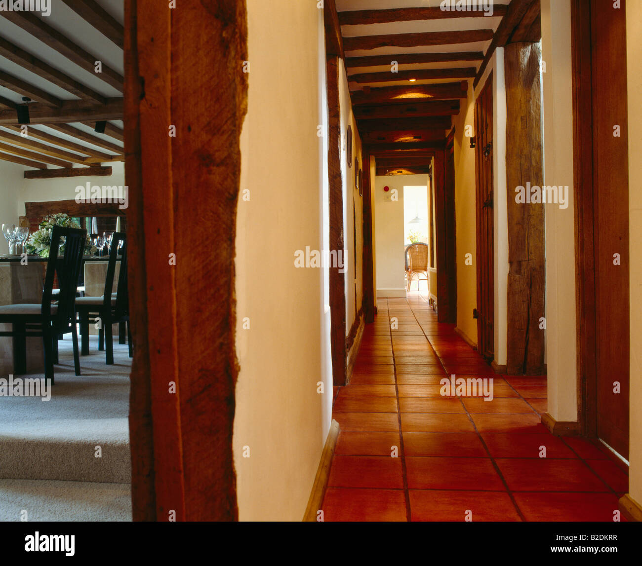 Terracotta tiles on floor in long corridor with beamed ceiling and ...