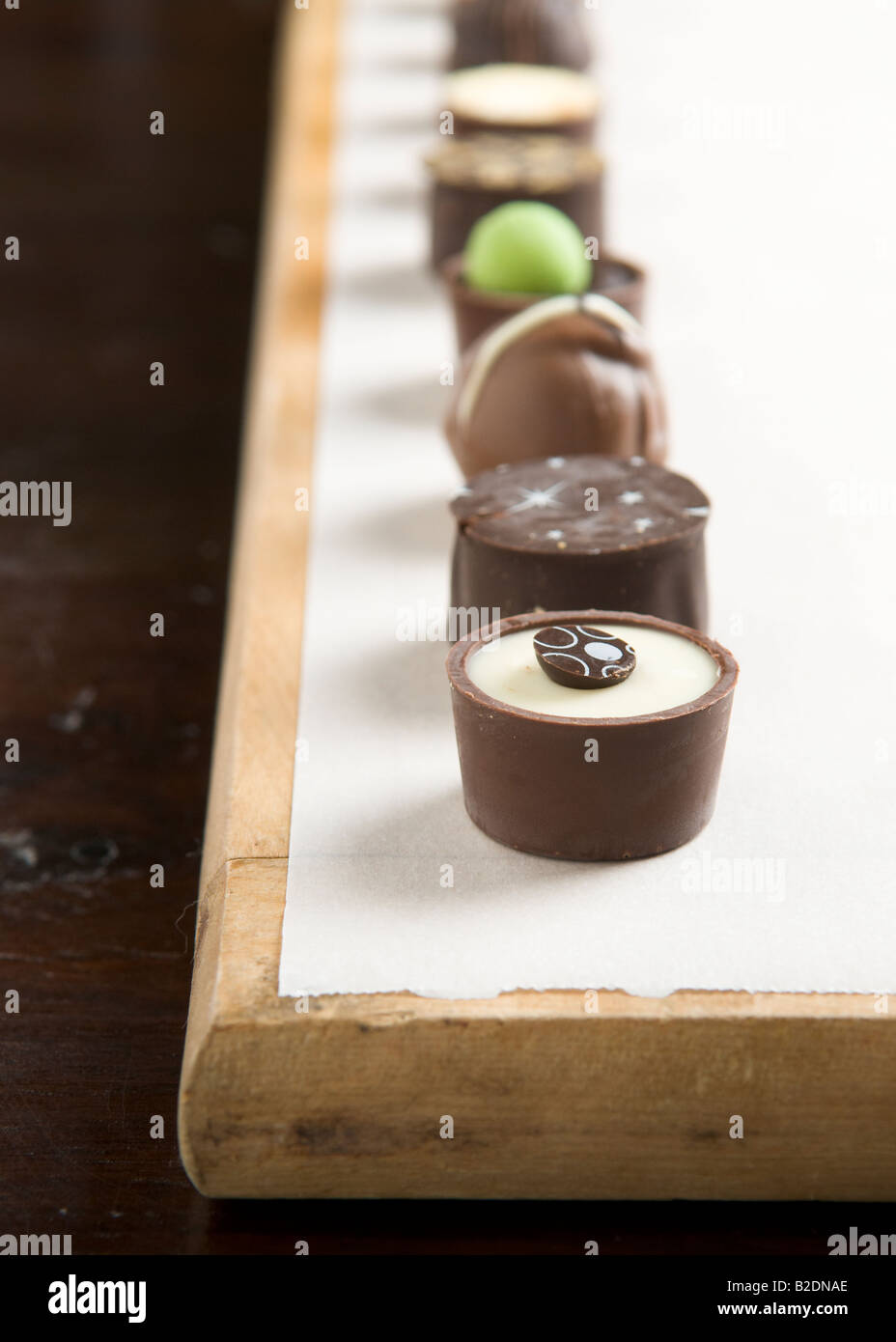 Small group of chocolates resting on parchment paper and a cutting ...