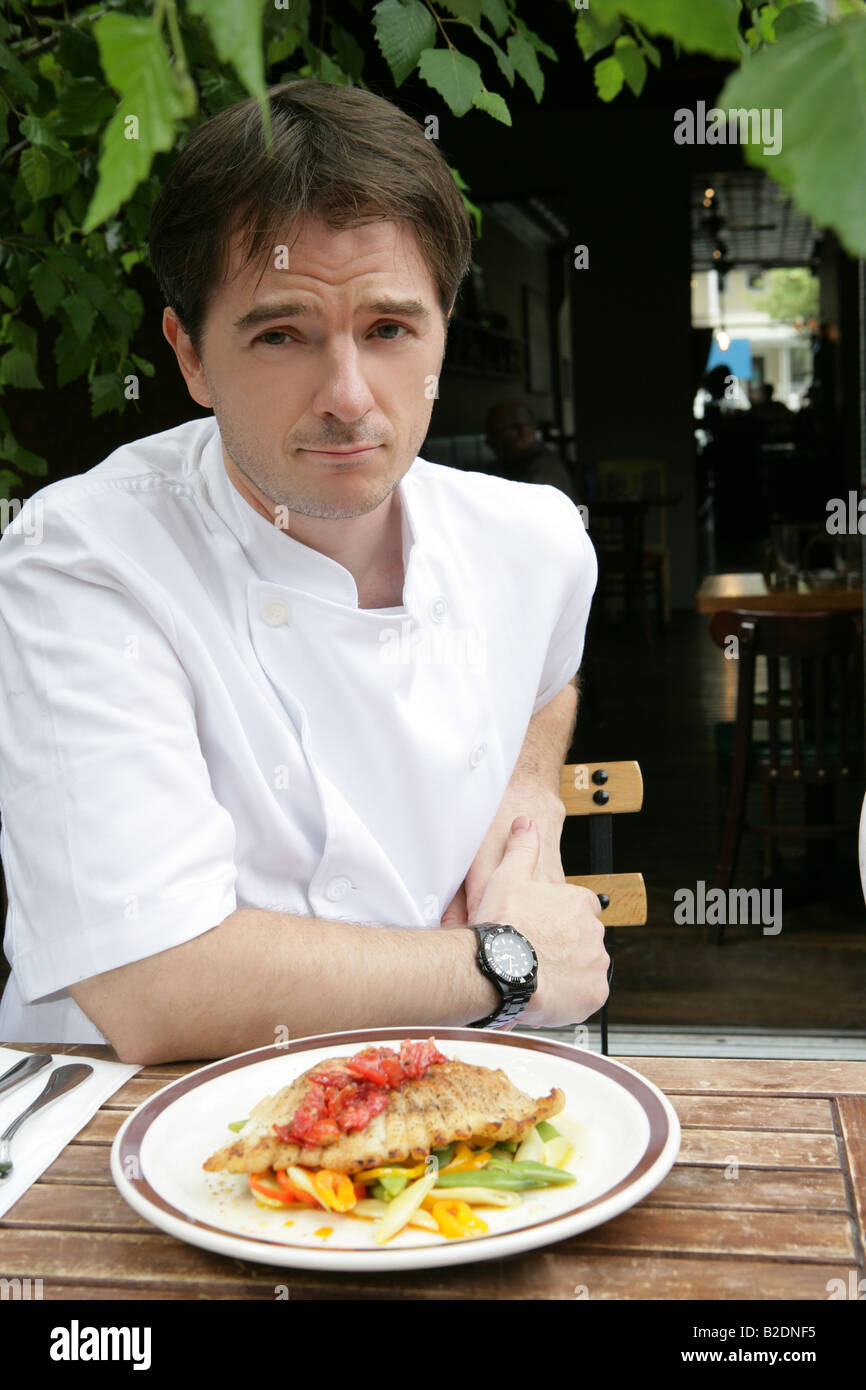 Male chef sitting at outdoor café with fish dish Stock Photo - Alamy
