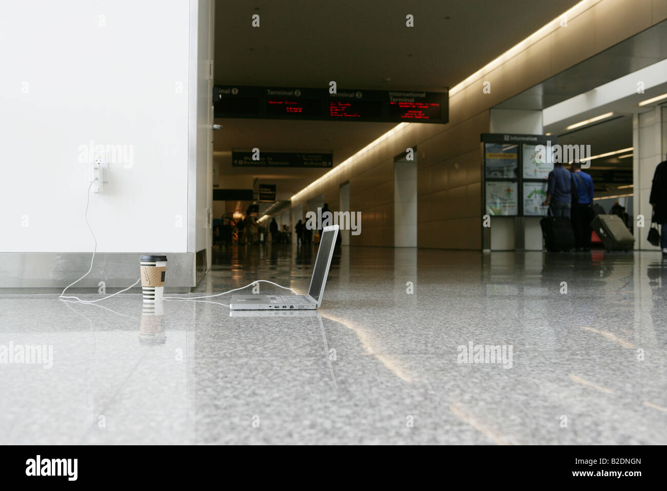 Laptop computer charging at airport Stock Photo - Alamy