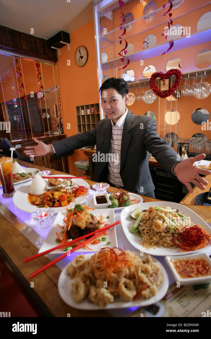 Asian man sitting in restaurant looking at array of food Stock Photo ...