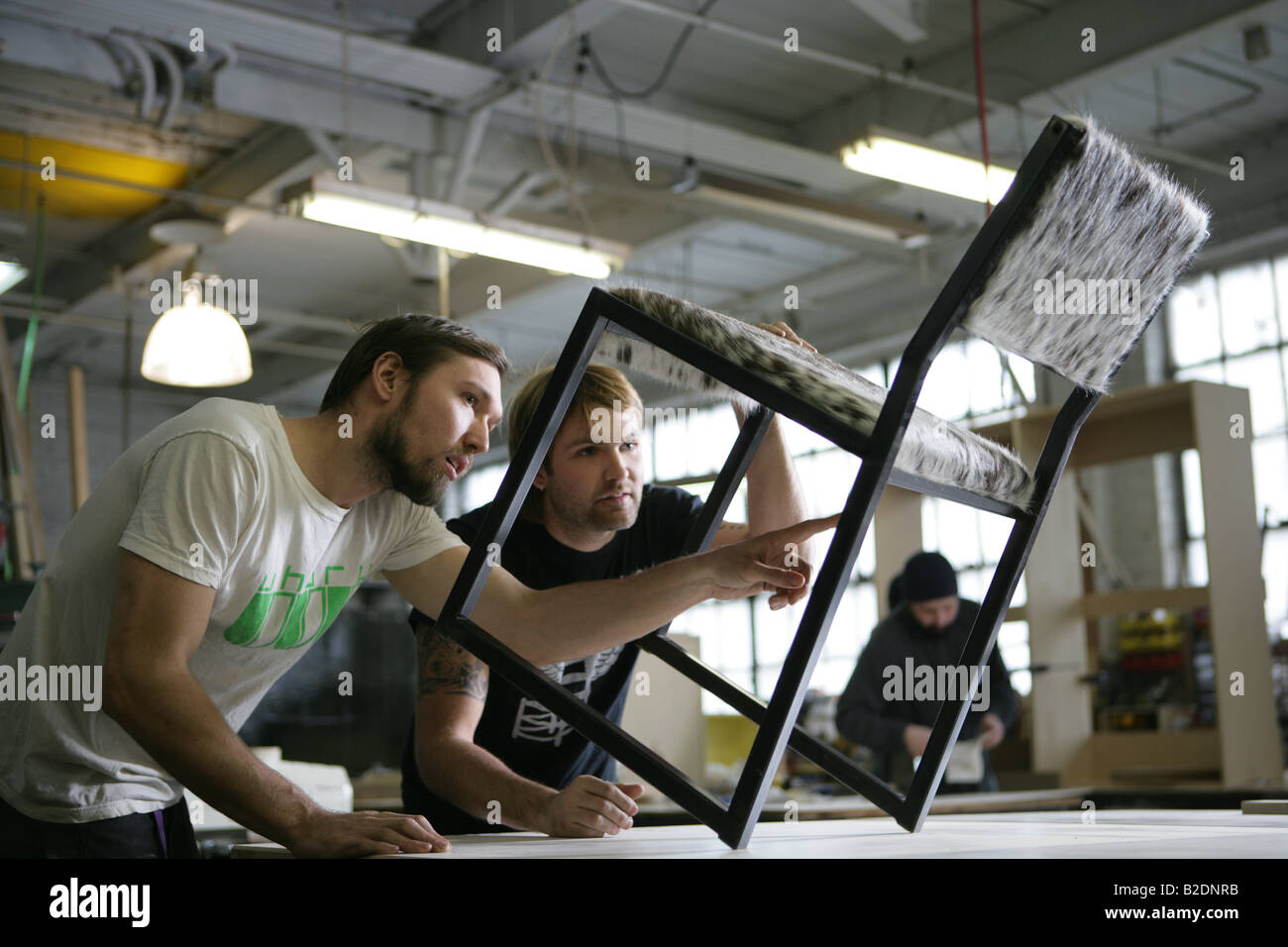 Men inspecting chair in warehouse Stock Photo - Alamy