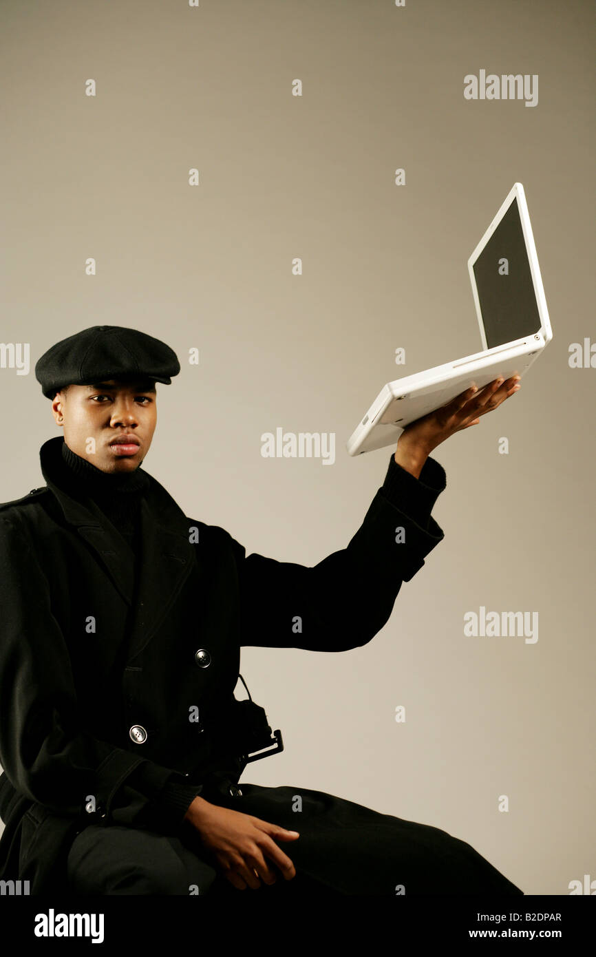 Young African American man holding laptop, studio shot Stock Photo - Alamy