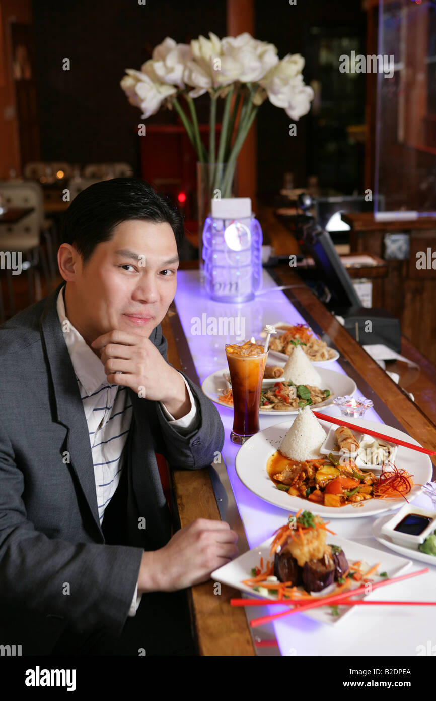 Asian man sitting in restaurant Stock Photo - Alamy