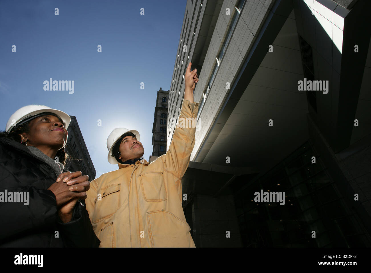 African American construction workers looking at building Stock Photo ...
