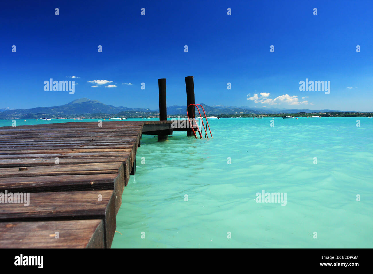 a small jetty in lake Garda Italy fantastic color in the water and sky ...
