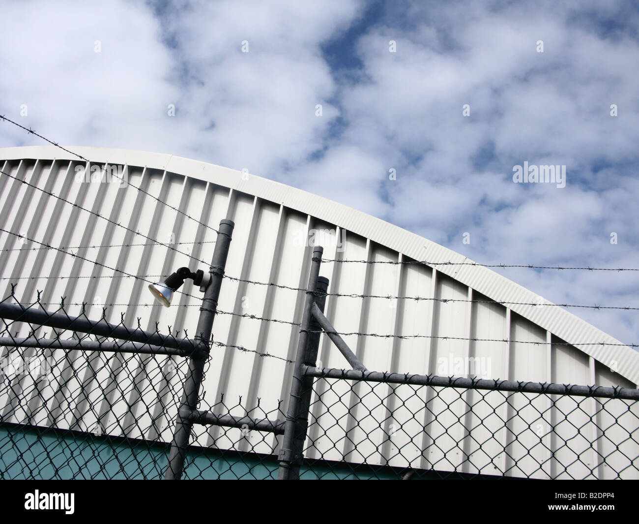 Building roof and wire security fence Stock Photo - Alamy
