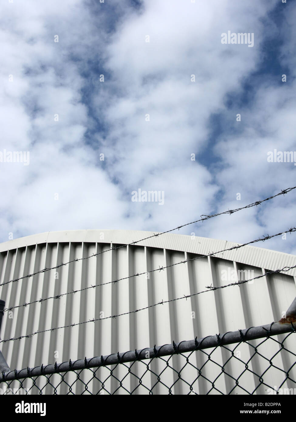 Building roof and wire security fence Stock Photo - Alamy