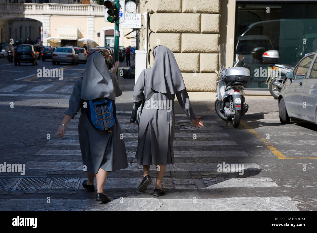 Two nuns dressed in black crossing road at pedestrian crossing Rome ...