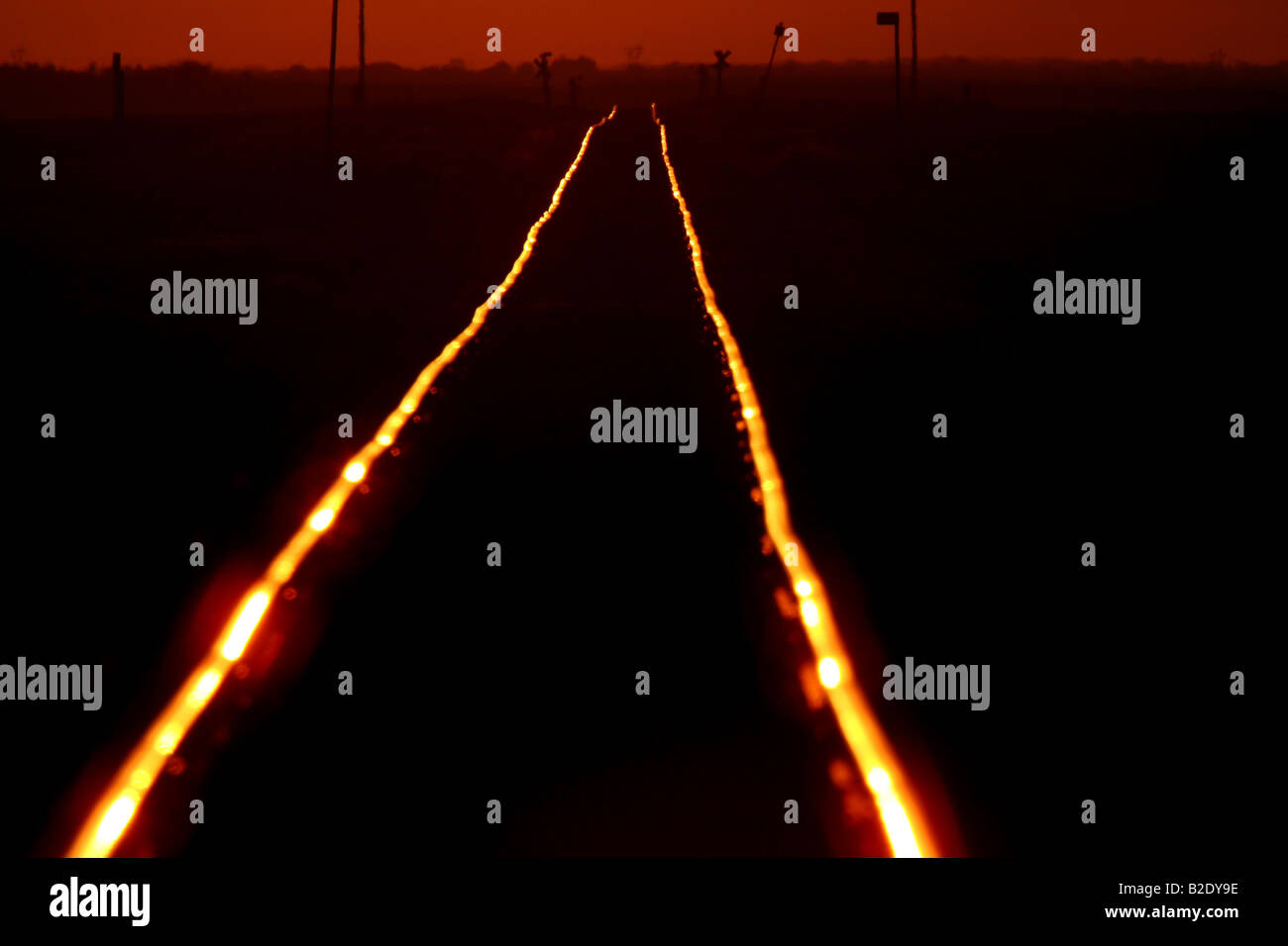 Setting sun shining on railroad tracks Stock Photo - Alamy