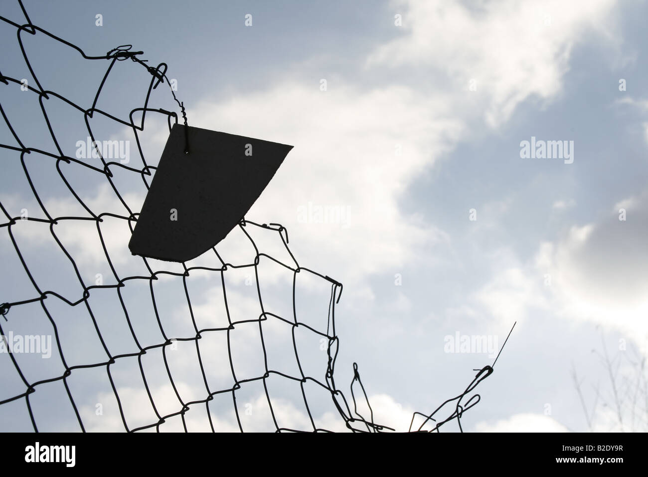 high broken damaged metal fence against dark sky Stock Photo - Alamy