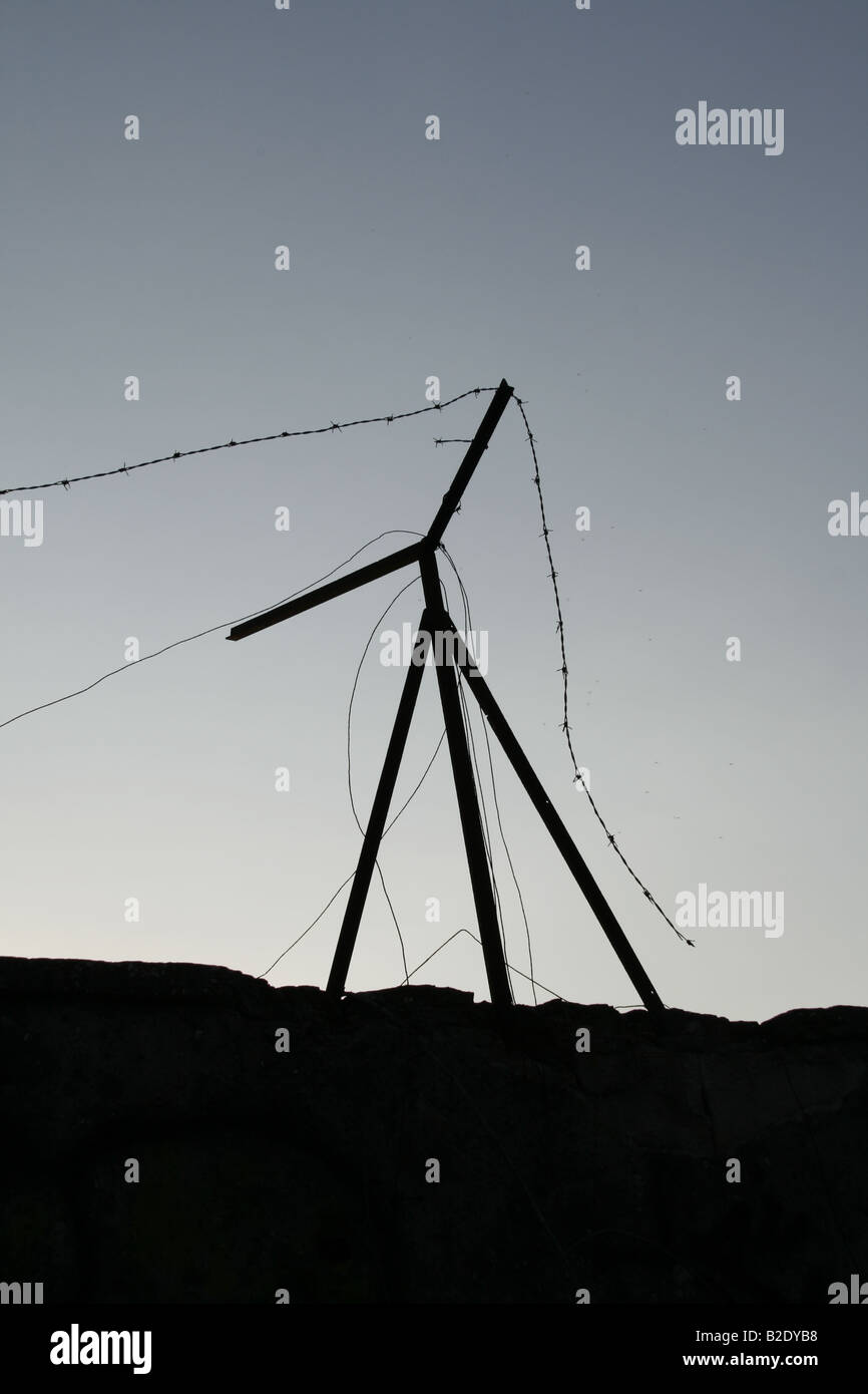 high wall fence with barbed wire outdoors at night Stock Photo - Alamy