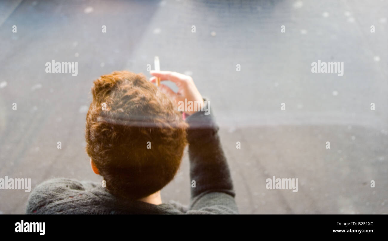 A guy smokes outside a window Stock Photo - Alamy
