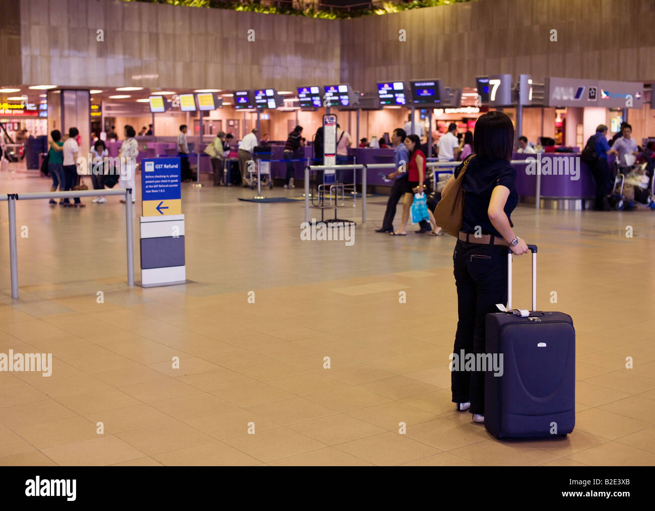 Passenger approaching check-in counter at a busy airport Stock Photo ...