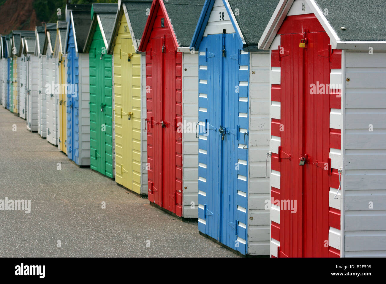 Row of colourful beach huts on the promenade at Seaton, Devon, England ...