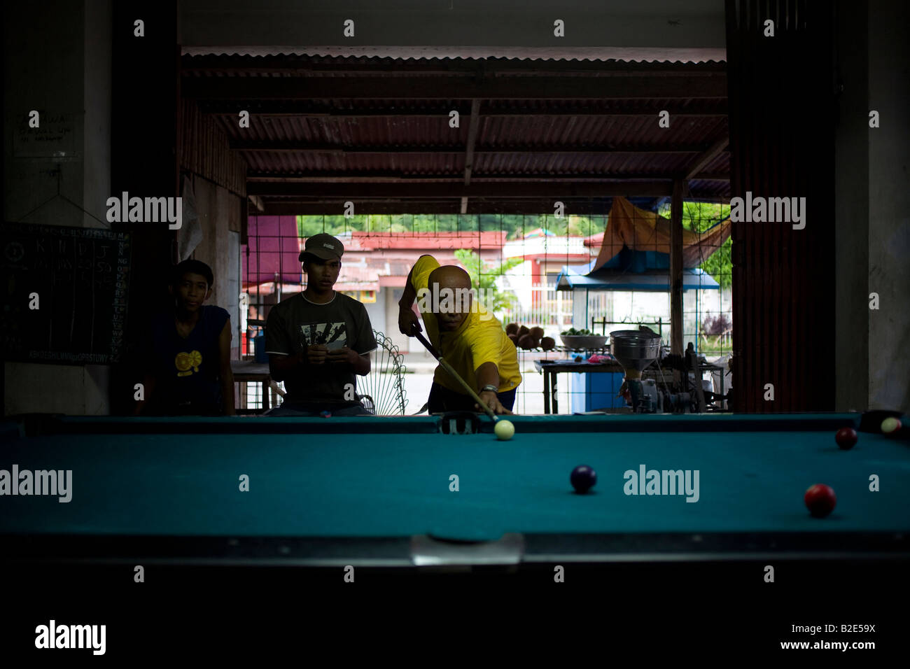 Filipinos play billiards in a billiard hall in Mansalay, Oriental ...