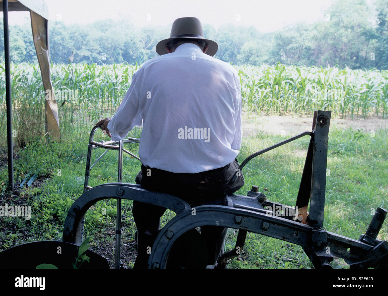 USA New England disabled farmer sitting on machine part on farm Stock ...